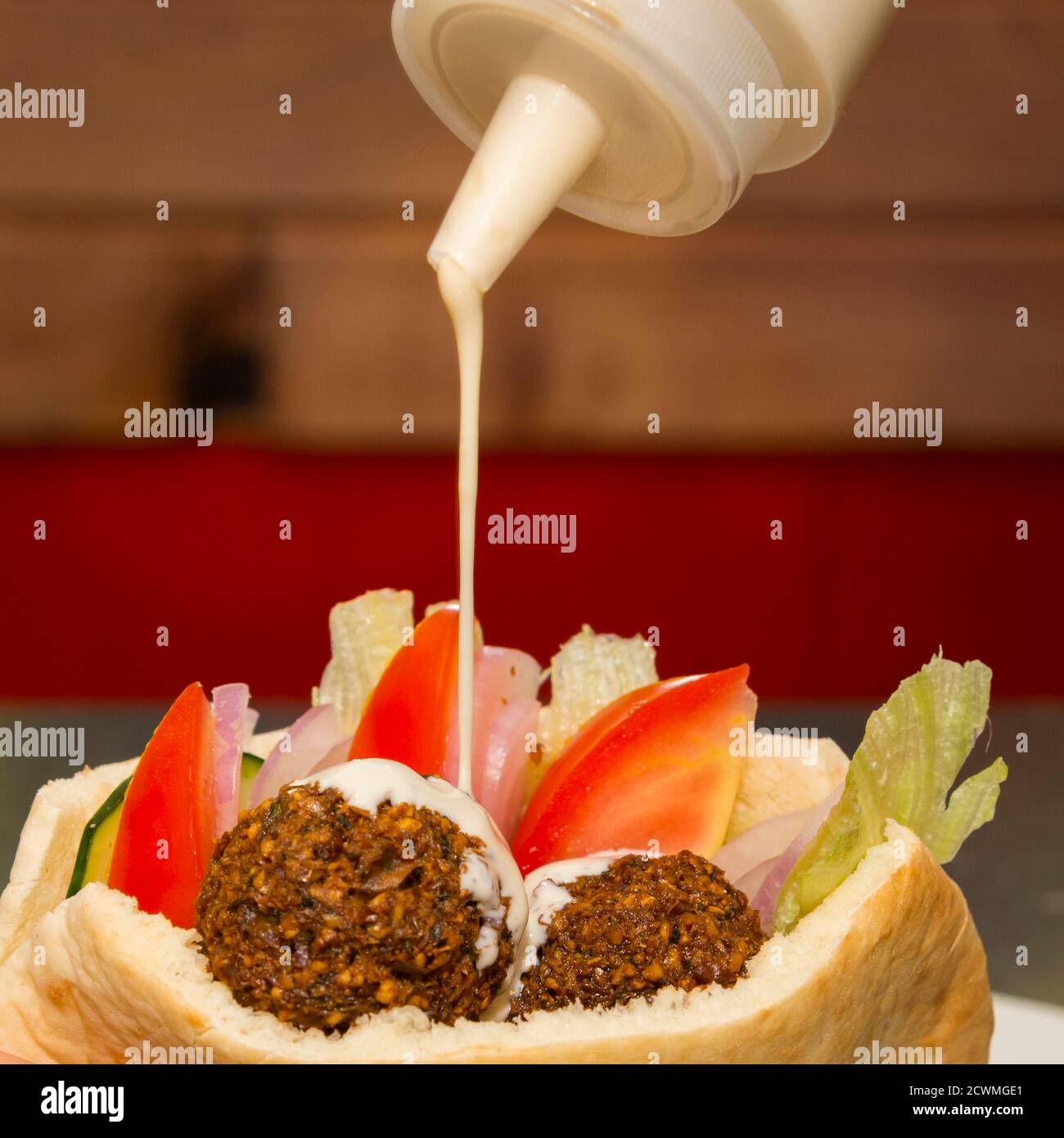 Pita bread filled with falafel, vegetable salad and tahina sauce Stock ...