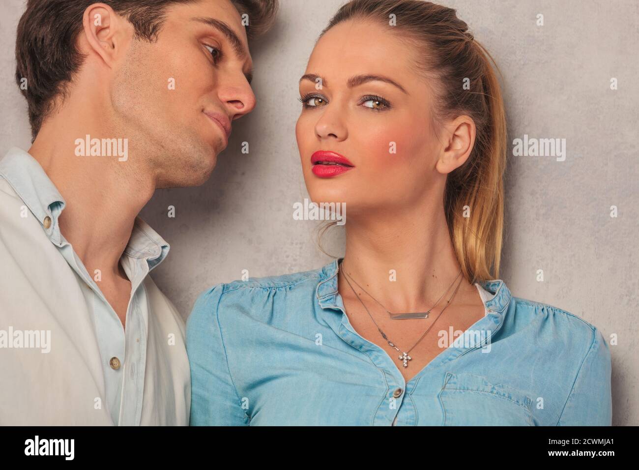 portrait of beautiful woman posing in studio background while boyfriend ...