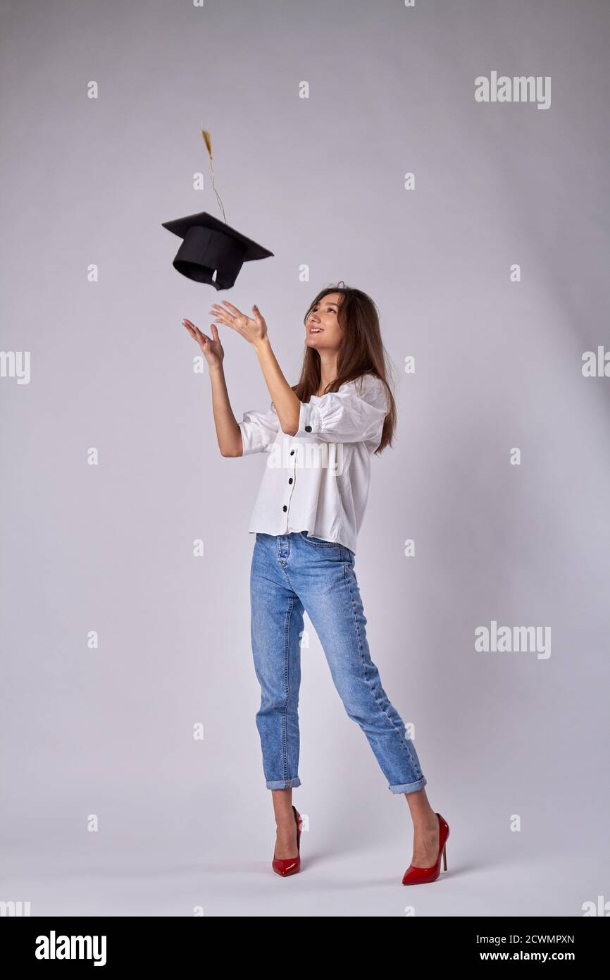 Smiling caucasian girl is throwing up her graduate hat Stock Photo - Alamy