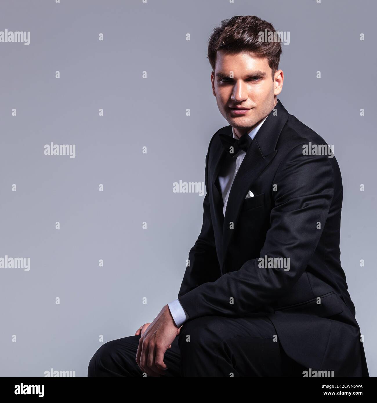 Side view picture of a young smiling business man sitting Stock Photo ...