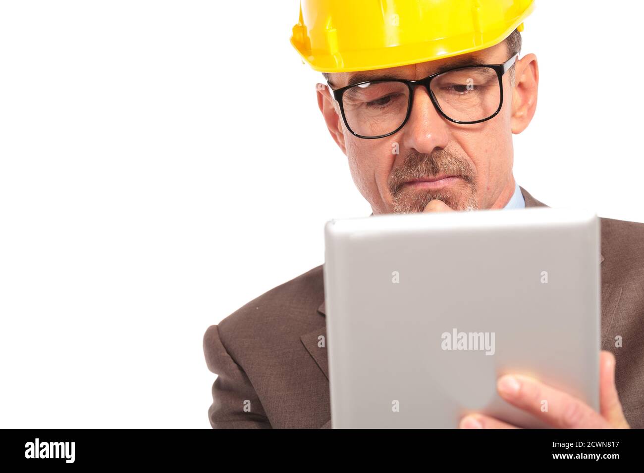 concerned senior construction engineer reading on his tablet computer ...
