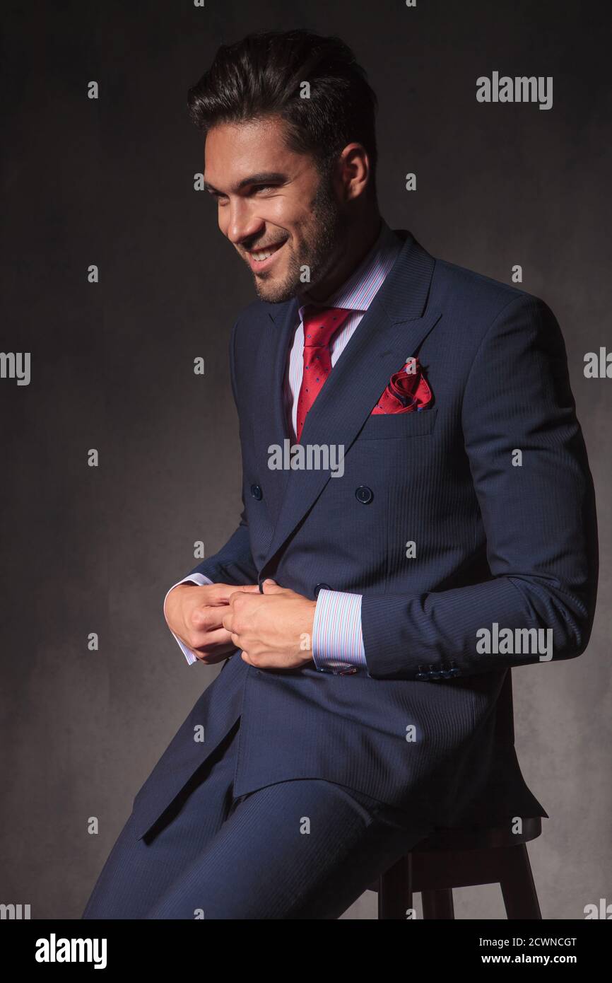Side view of a smiling young business man opening his jacket while ...