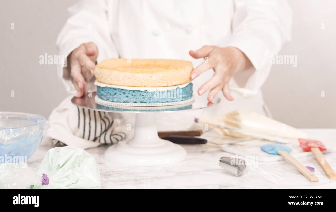 Stacking cake layers to create the round three-layer vanilla cake Stock ...