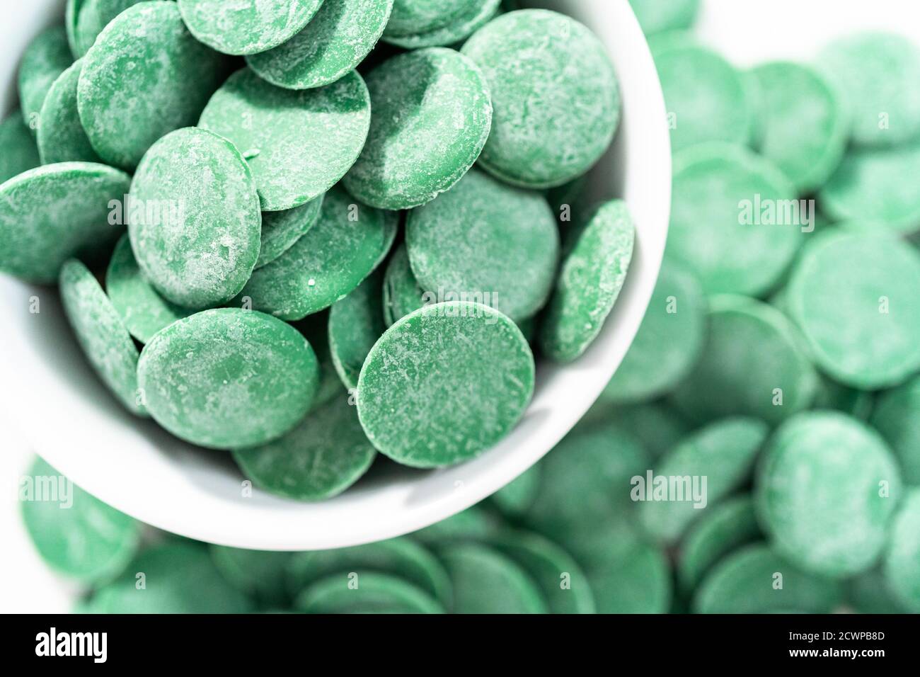Green round chocolate chips for melting chocolate shapes on a white ...