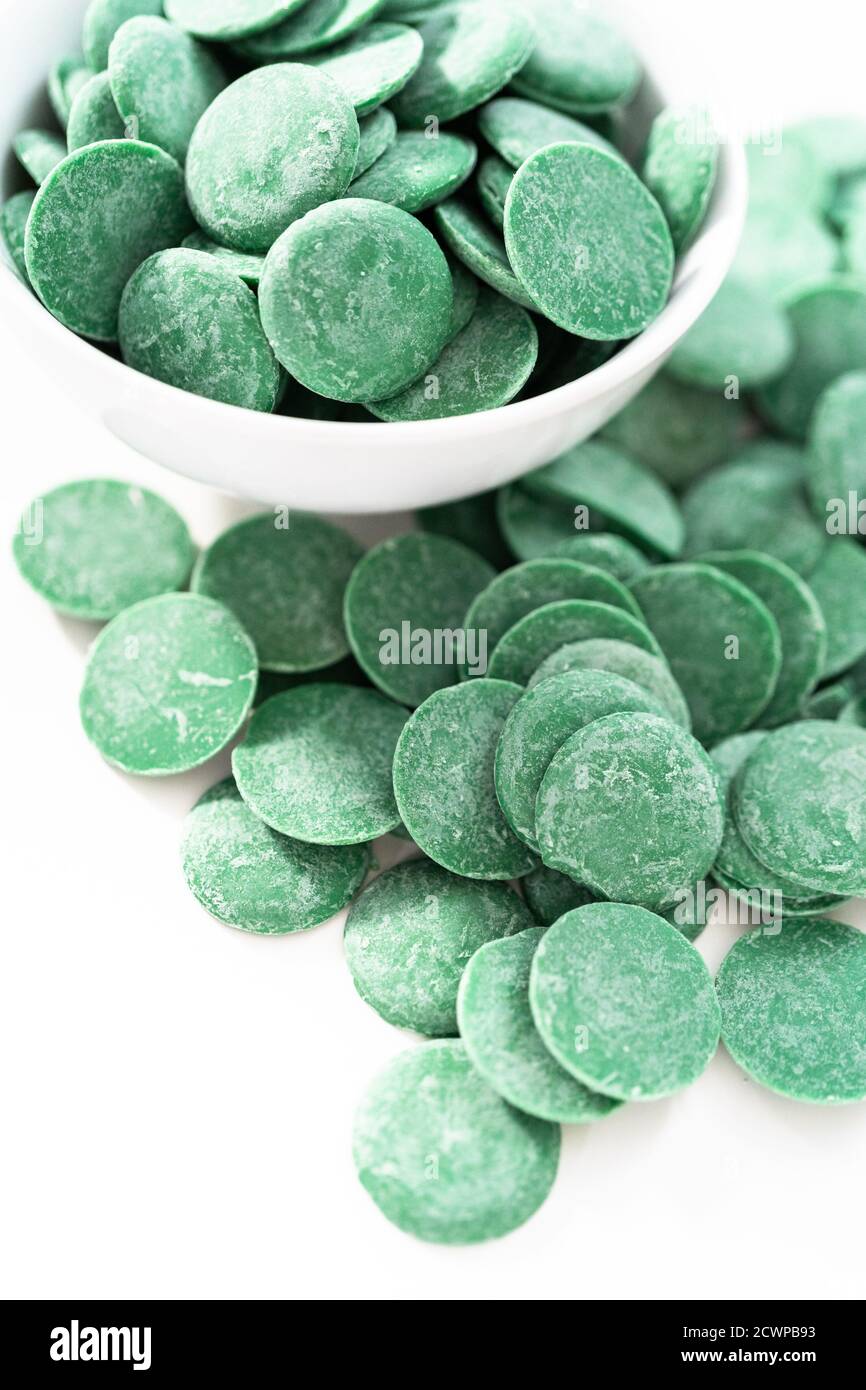 Green round chocolate chips for melting chocolate shapes on a white ...