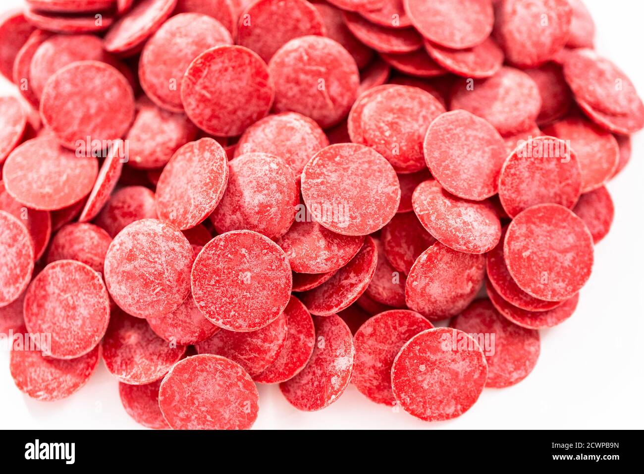 Red round chocolate chips for melting chocolate shapes on a white ...