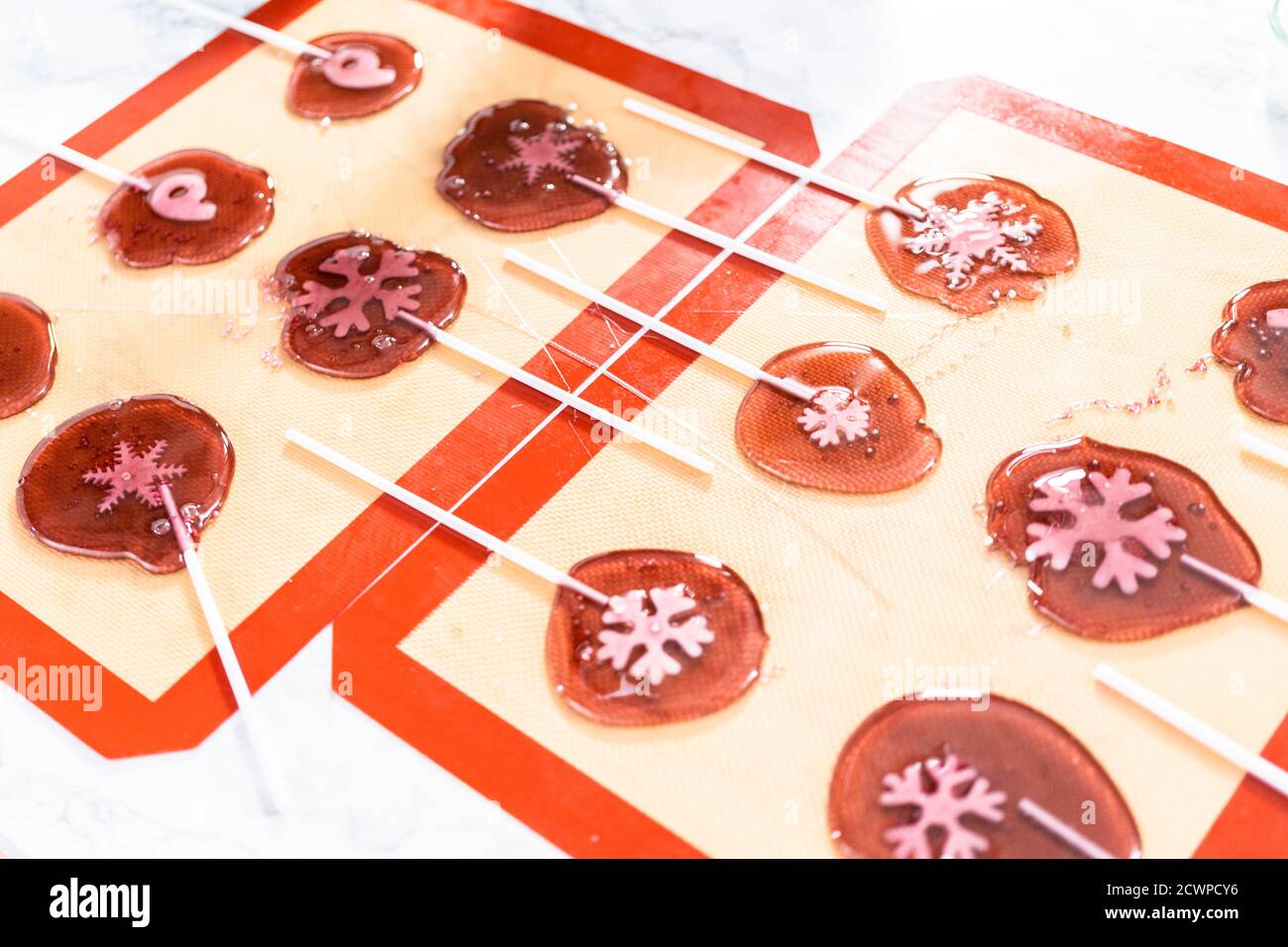 Making homemade berry flavor lollipops with snowflakes Stock Photo - Alamy