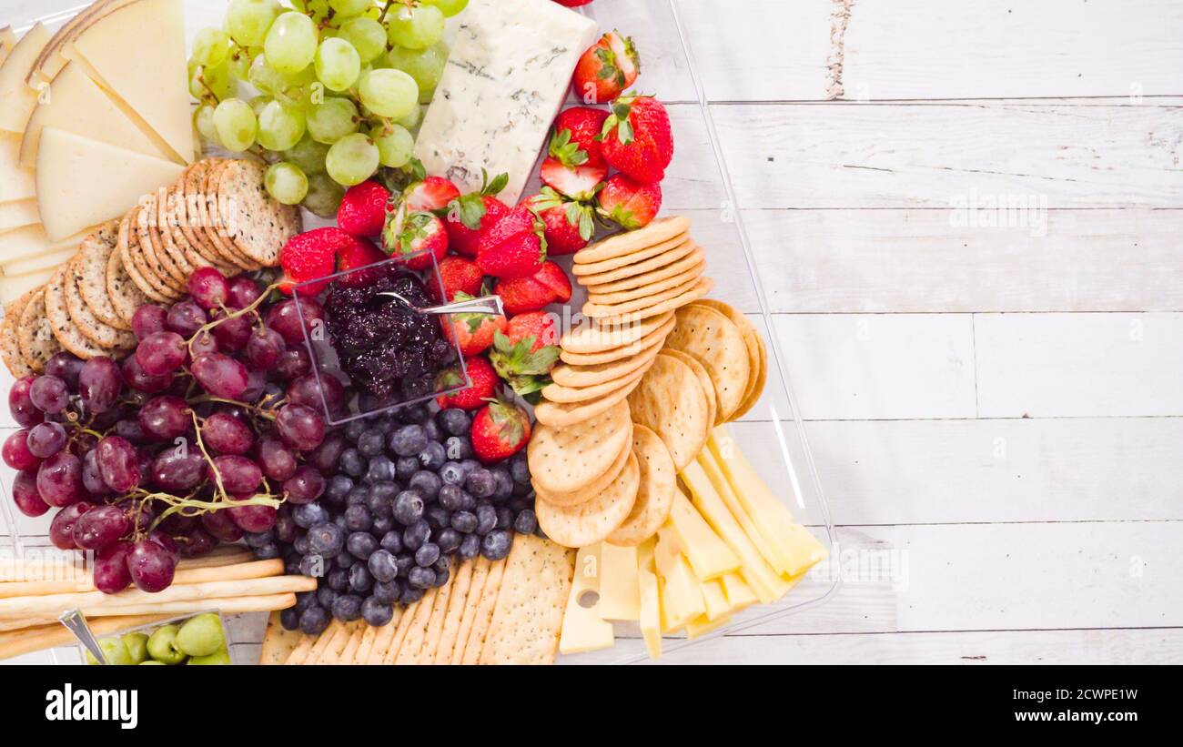 Flat lay. Step by step. Arranging cheese platter with fresh fruits ...