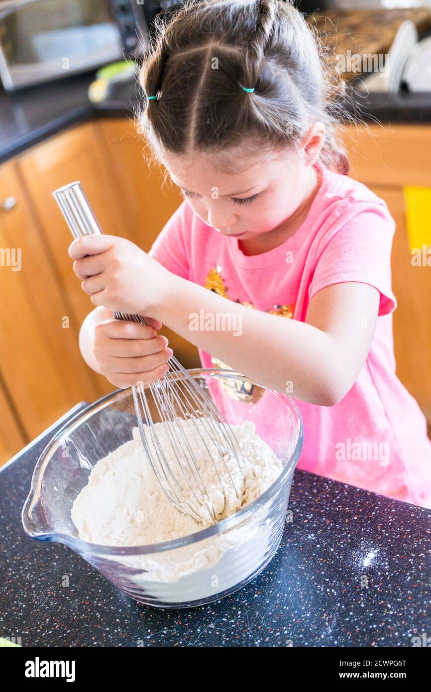 Little girl helping mixing dough to bake flatbread Stock Photo - Alamy