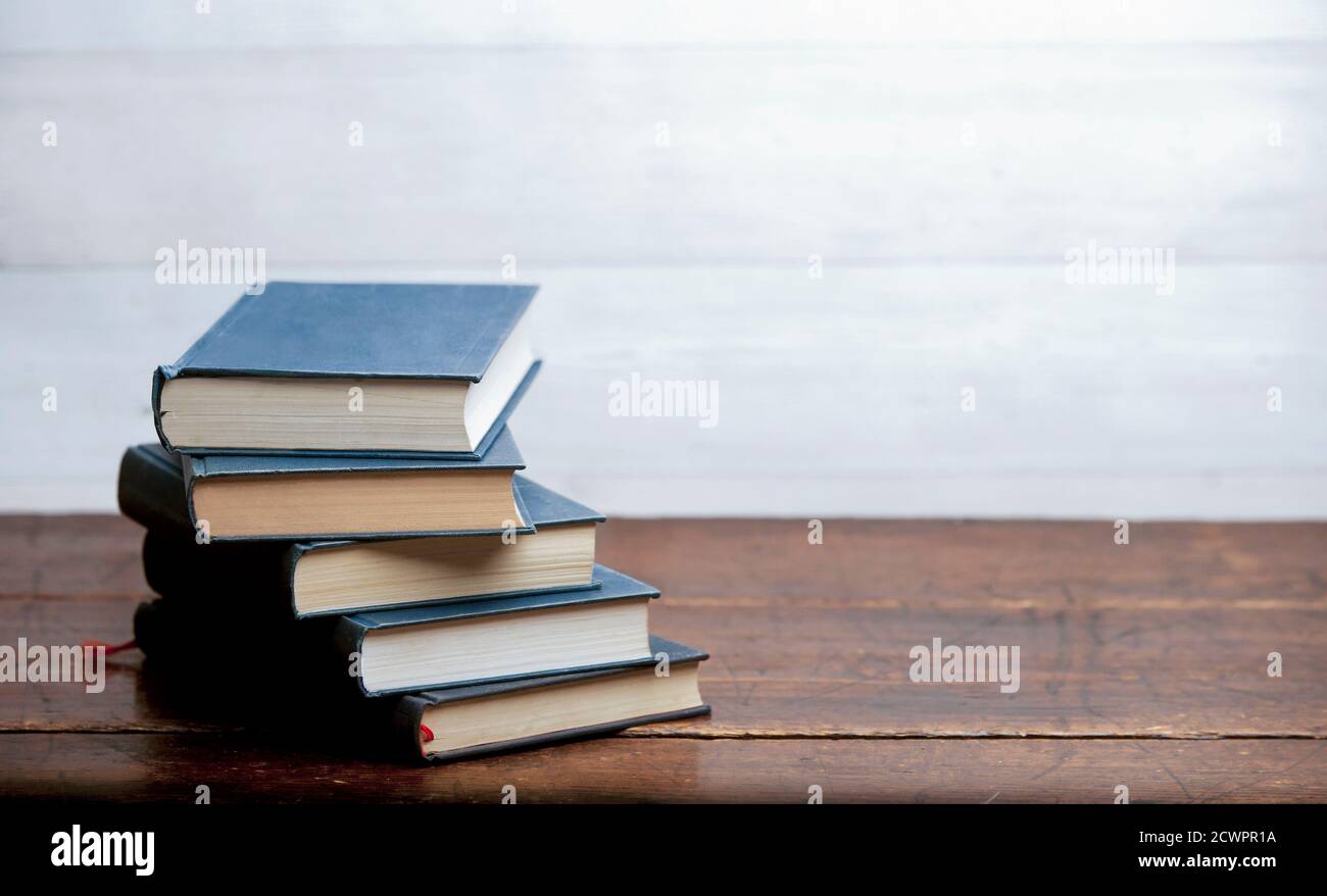 stack of blue books on old wooden shelf with dark background Stock ...