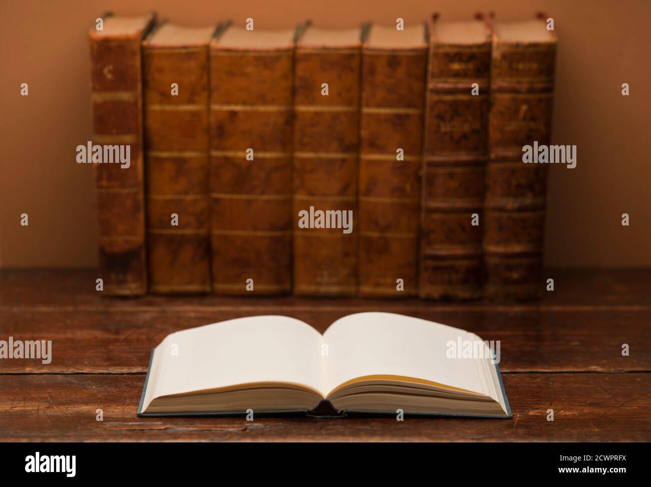 old books on wooden desk, with open book Stock Photo - Alamy