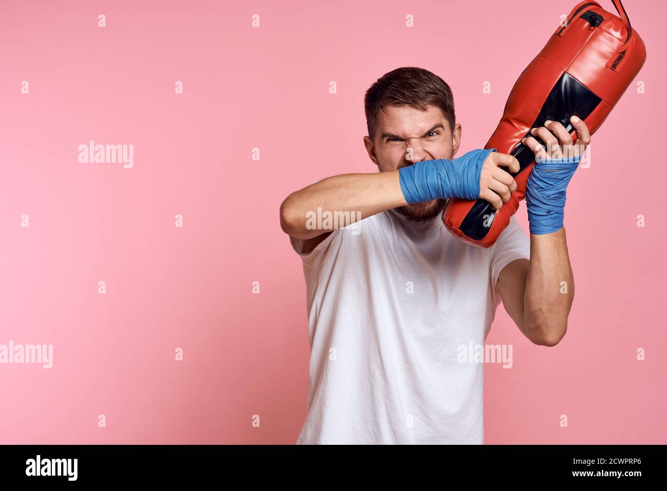Man practicing blows on a pear boxing bandages fitness lifestyle pink ...