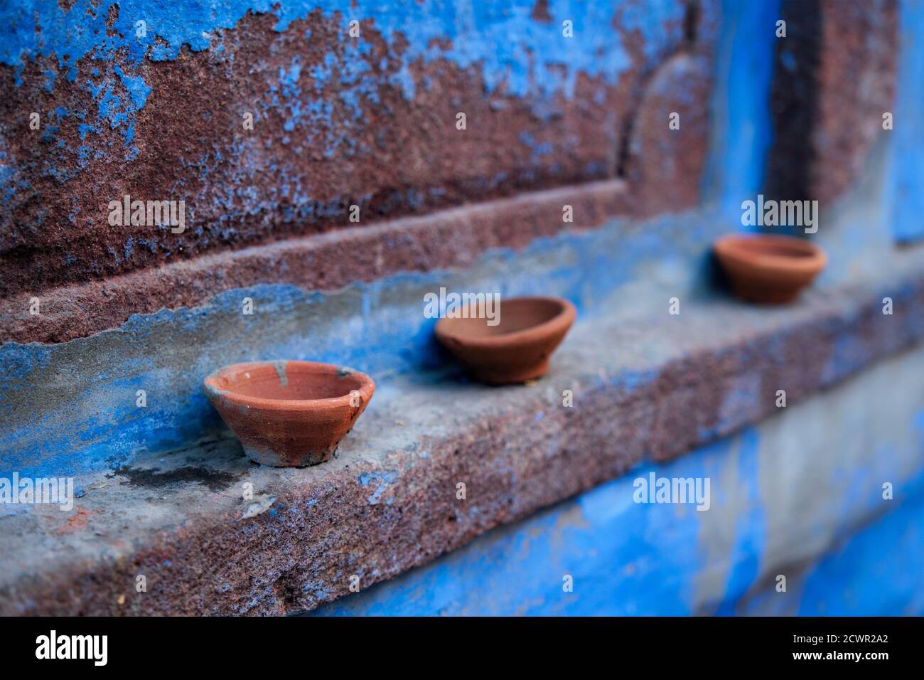 Oil Lamp Pooja Diya Lamp on blue house wall in Jodhpur, Rajasthan ...