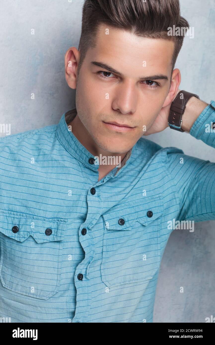 Close up picture of a handsome young man holding his hand to his neck ...