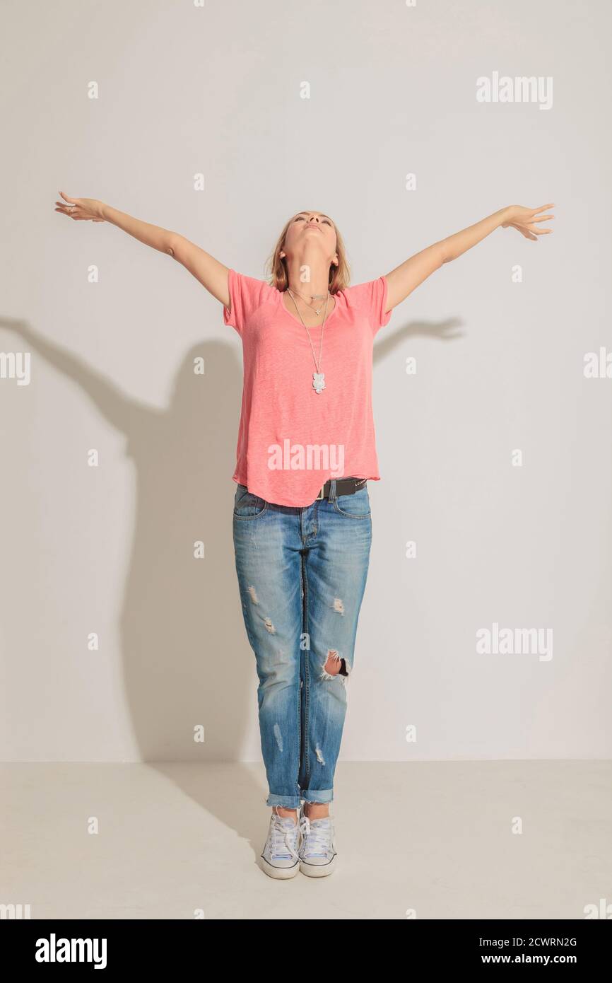 Full body picture of a casual woman holding both hand in the up ...