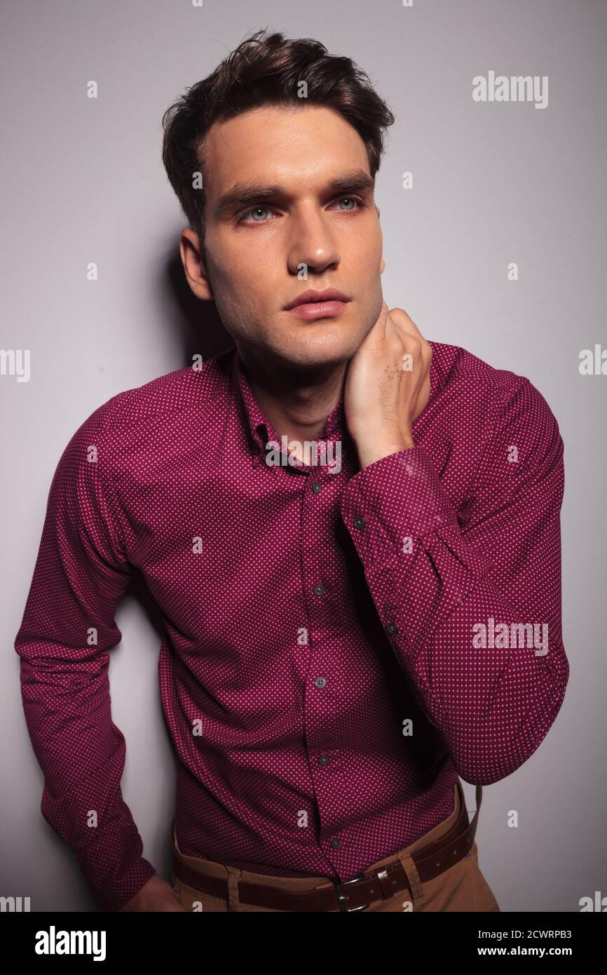 Attractive young man looking awat from the camera while holding his ...