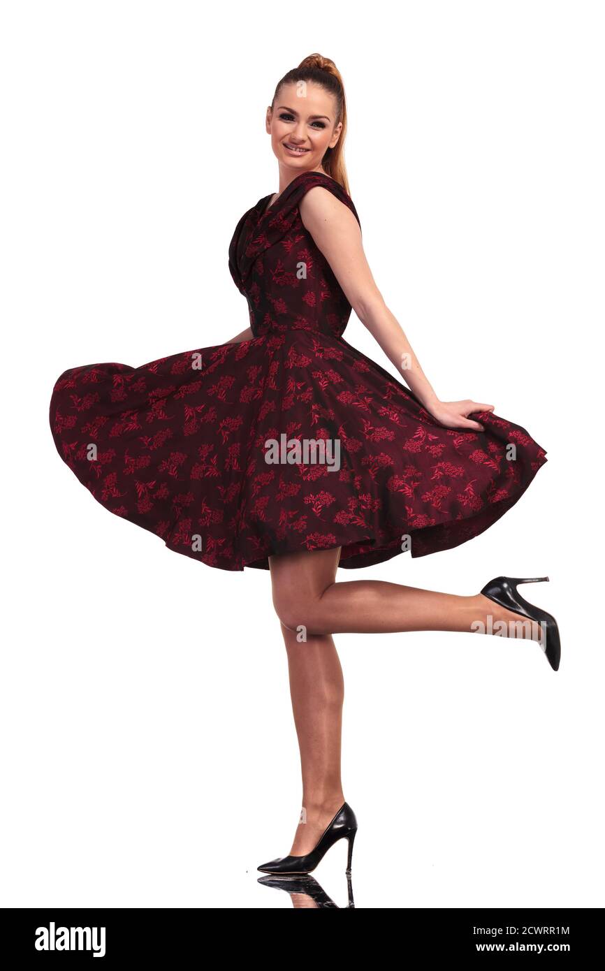 Blonde young elegant woman showing her dress while lifting one leg up ...