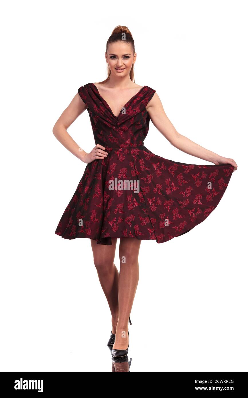 Young elegant woman holding one hand on her waist while showing her ...