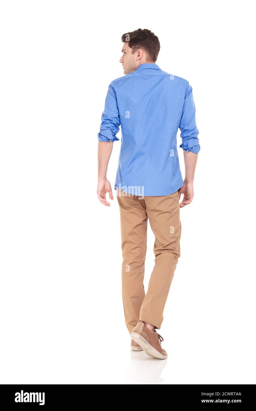 Back view of a young fashion man walking on isolated background looking ...