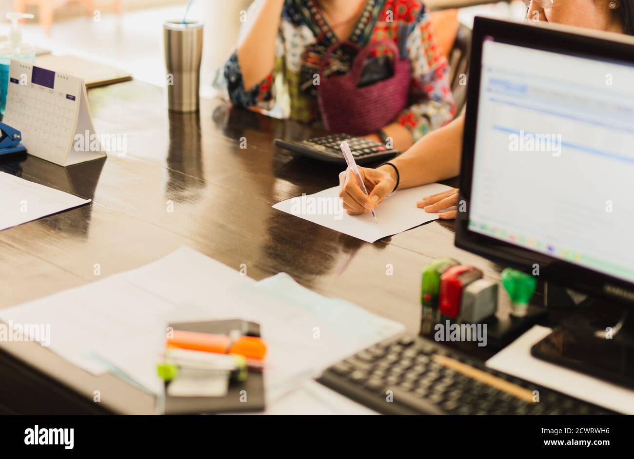 Businesswoman hand signing hotel agreement contract at reception desk ...