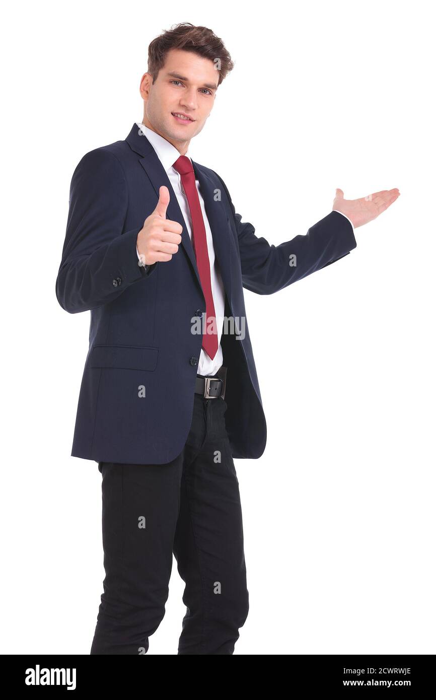 Side view of a young business man showing the thumbs up gesture while ...