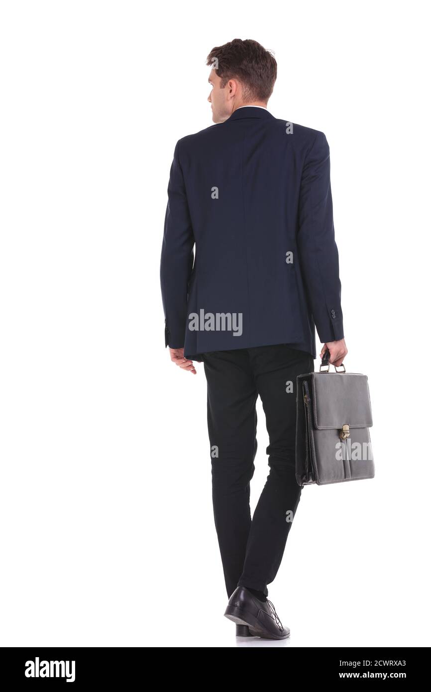 Back view of a tall business man walking while holding his briefcase ...