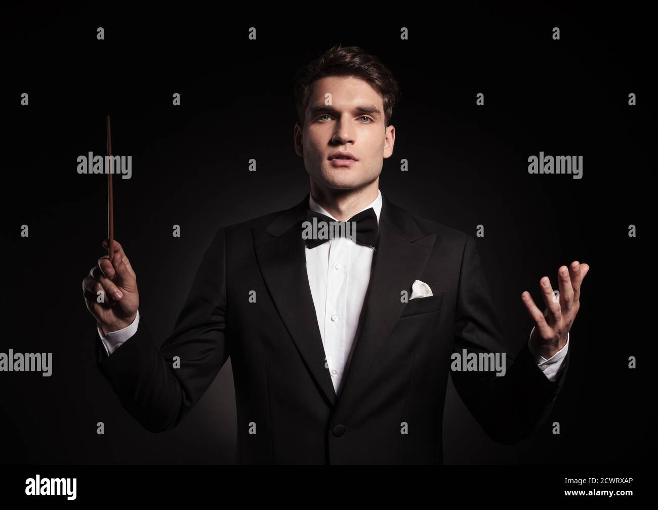 Young handsome man conducting an orchestra Stock Photo - Alamy
