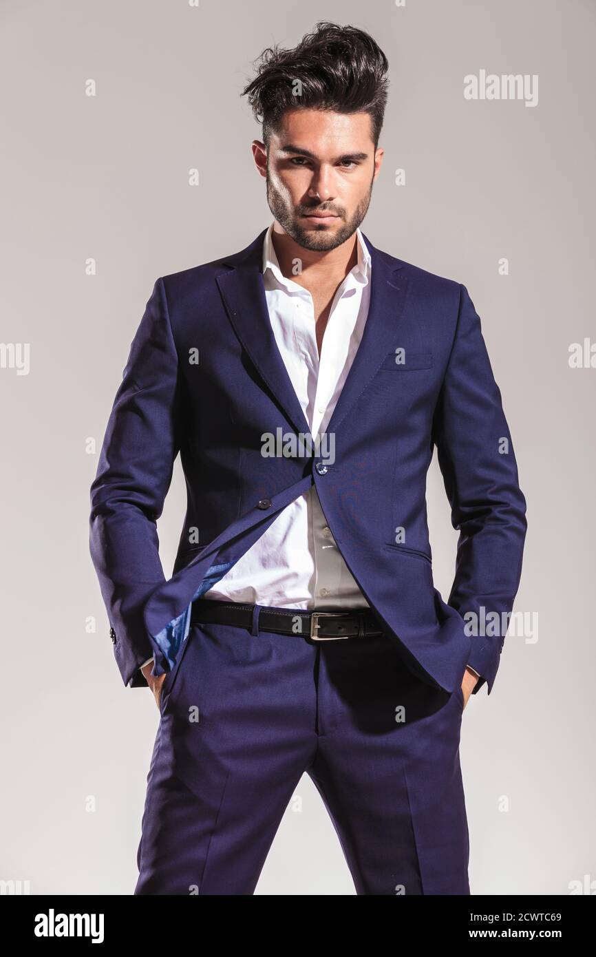 Young business man holding both hands in his pocket while looking at ...
