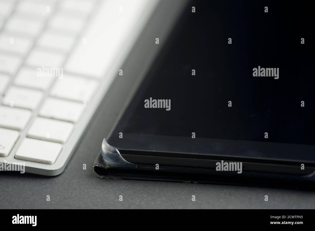Close-up, part of computer keyboard and part detail electronic tablet ...