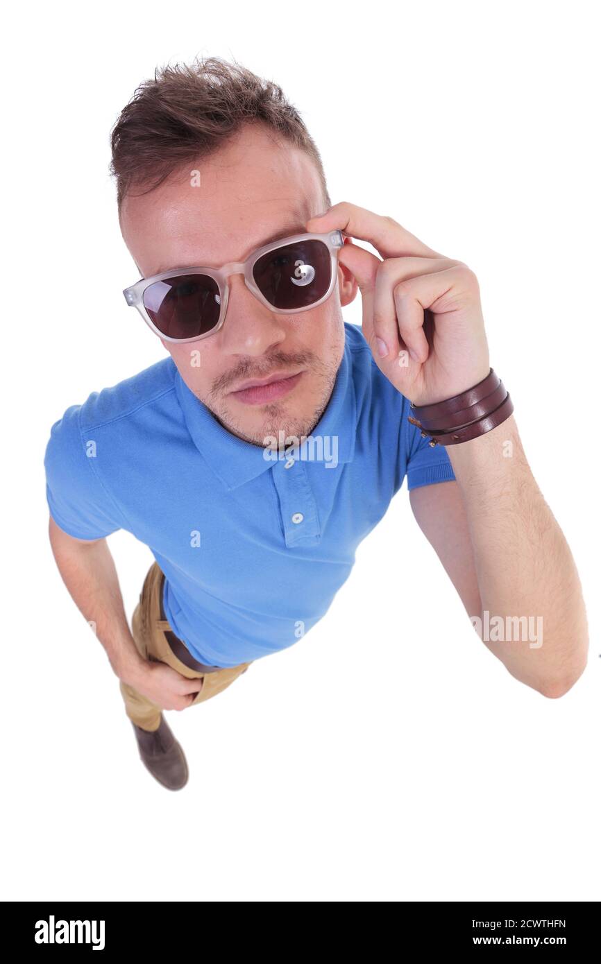 top view of a casual young man holding a hand on his sunglasses. on a ...