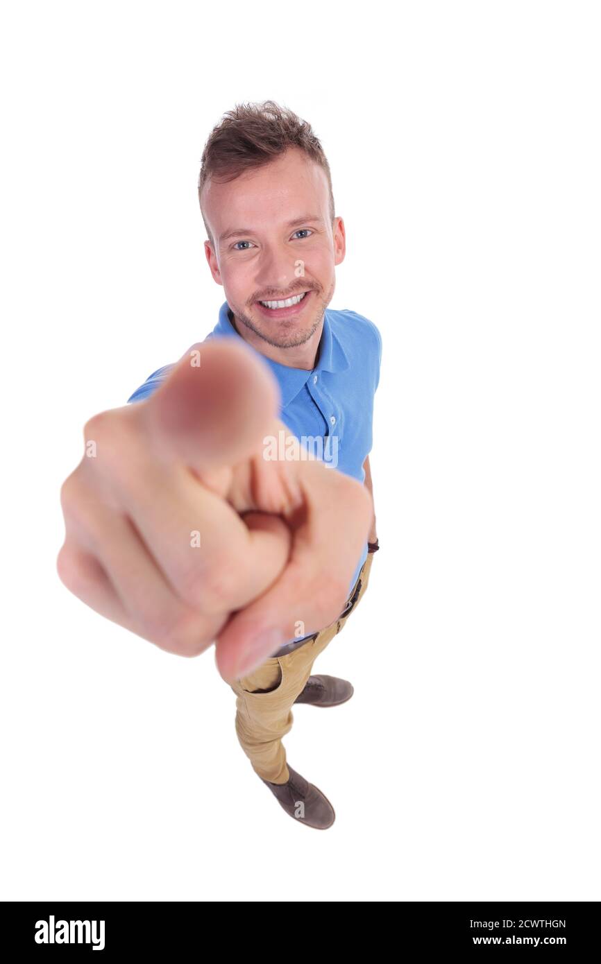 top view of a casual young man pointing towards the camera and smiling ...