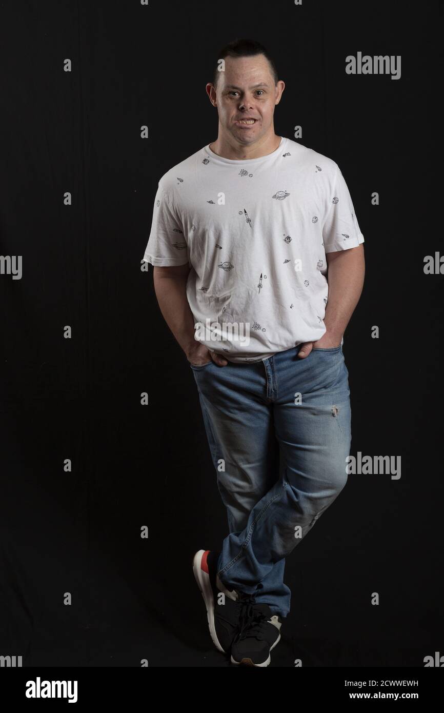 Happy man with down syndrome in the photo studio on black background ...