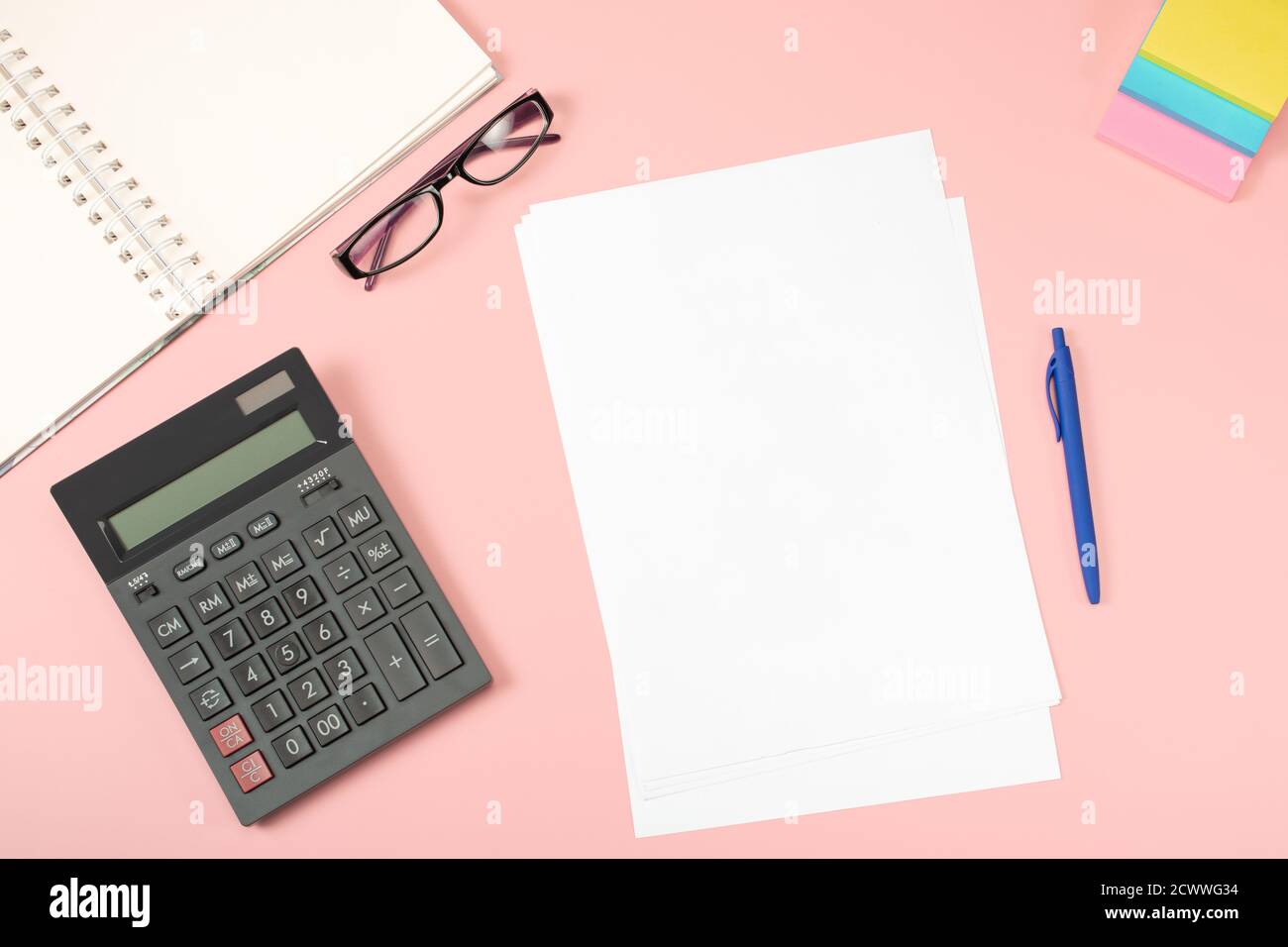 office flat lay. Blank white sheet of paper with pen are on top of pink ...