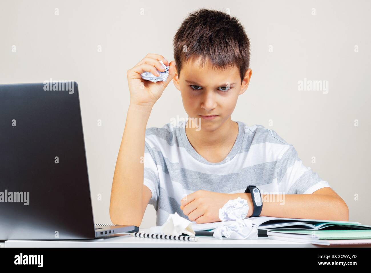 Sad dissapointed kid doing homework on laptop computer. Boy hand ...