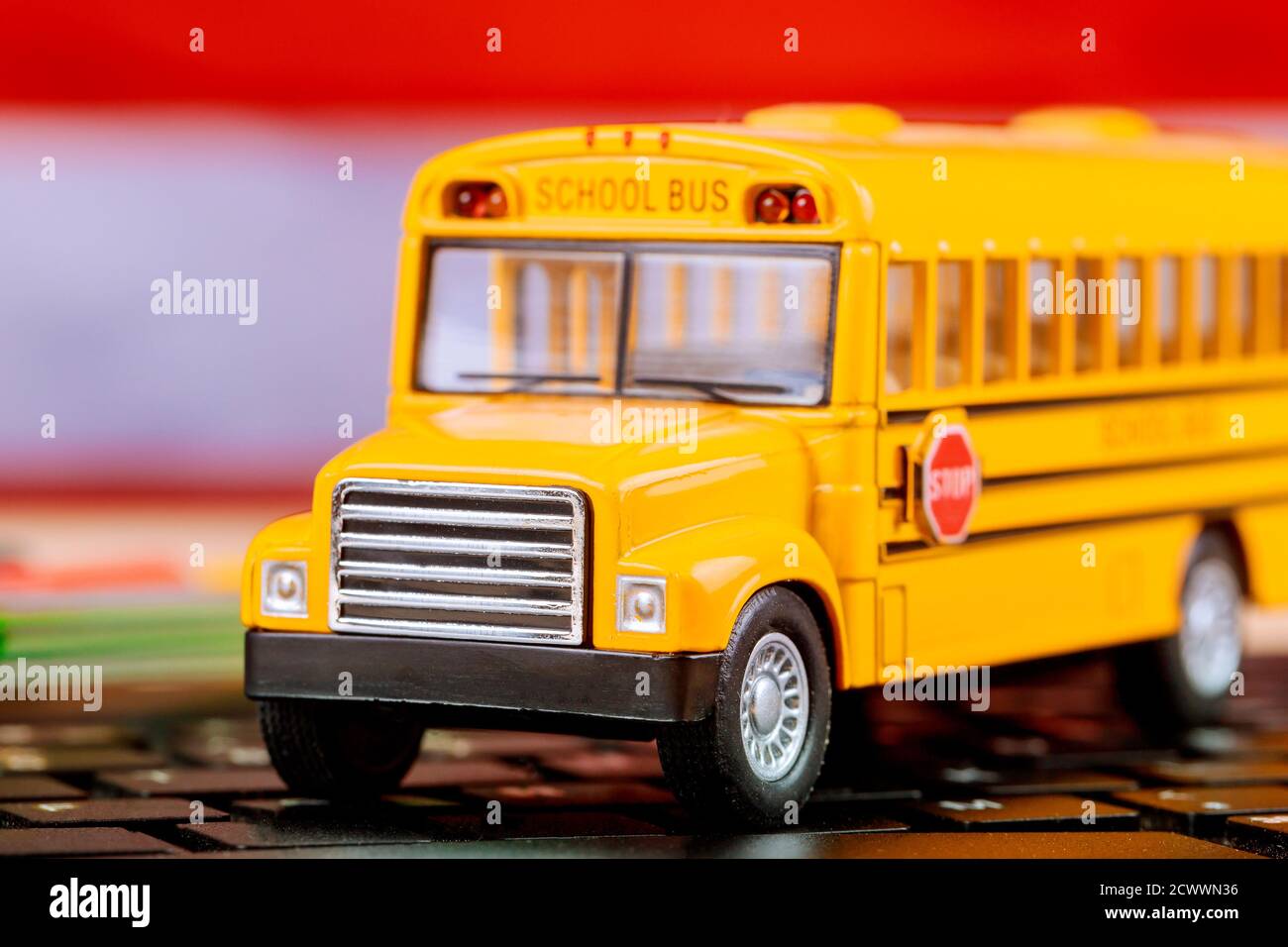 Online remote learning school with yellow school bus on laptop keyboard ...