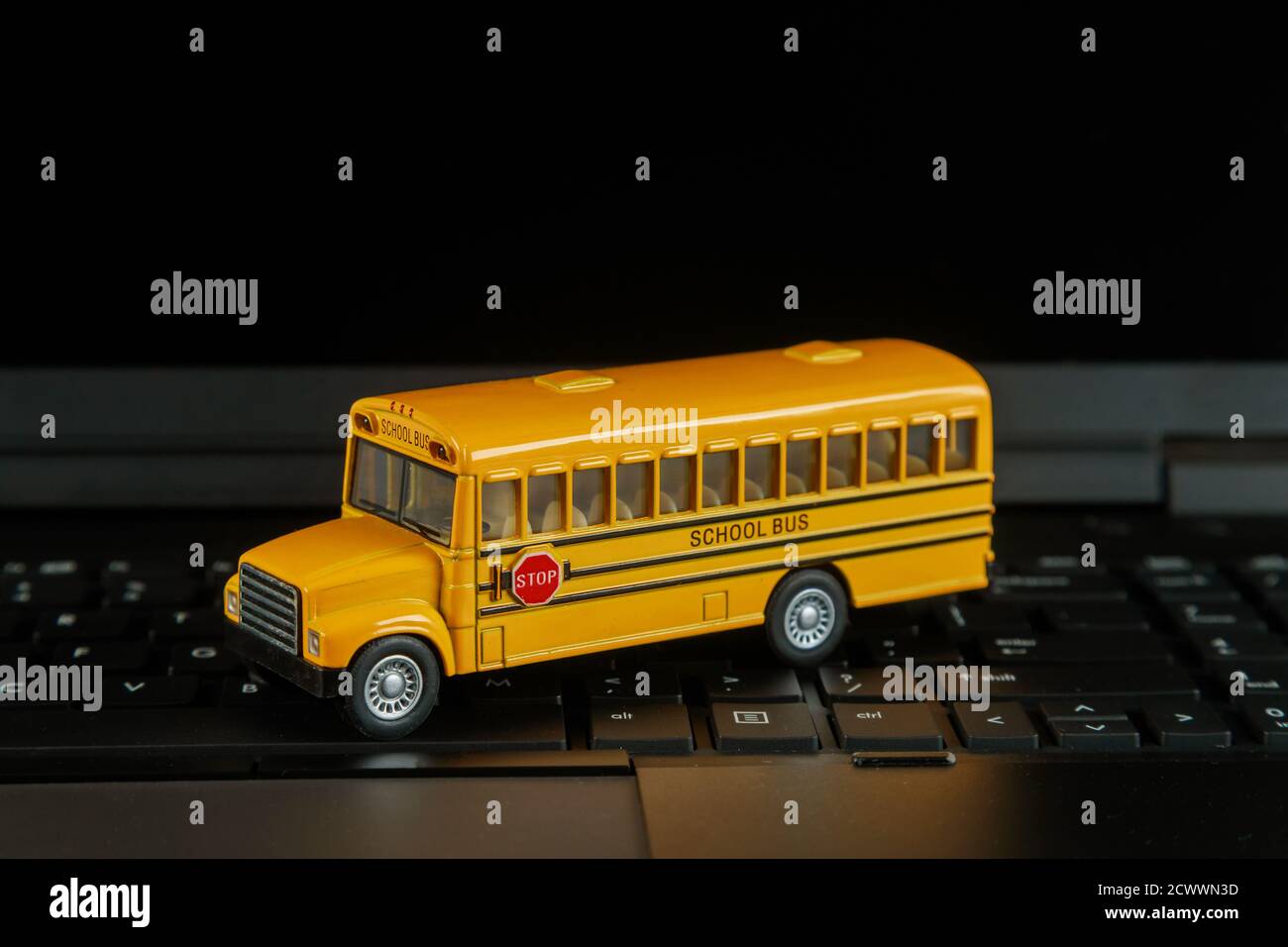 School bus on computer keyboard close up with online lesson back to ...