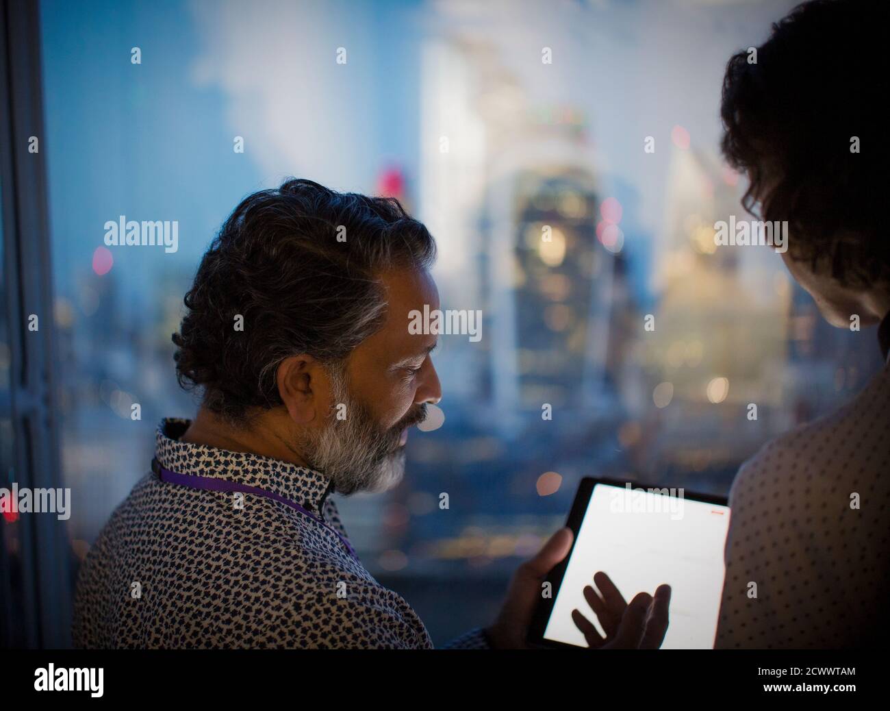 Business people with digital tablet working late at office window Stock ...