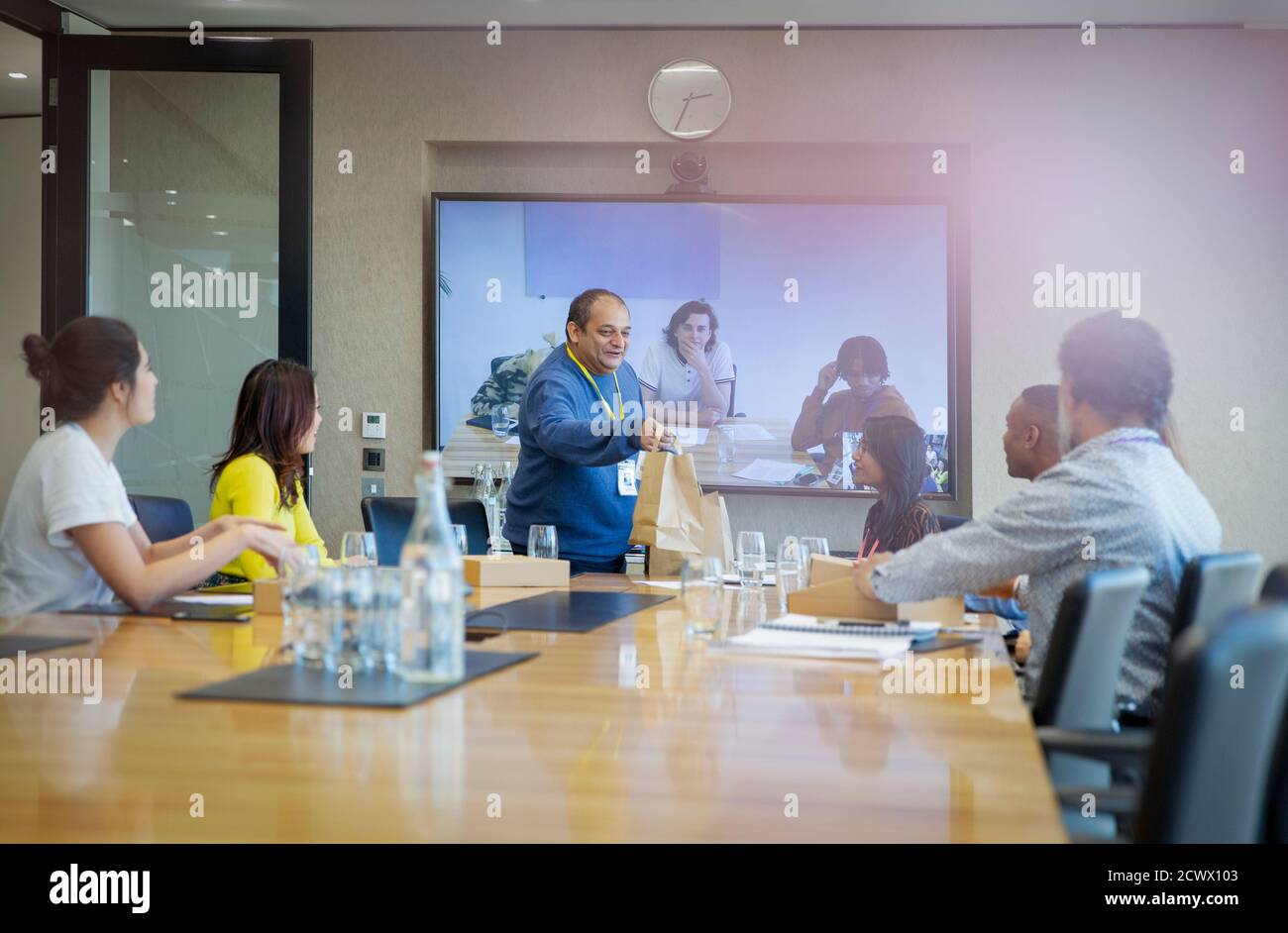 Businessman delivering lunch to colleagues in conference room meeting ...