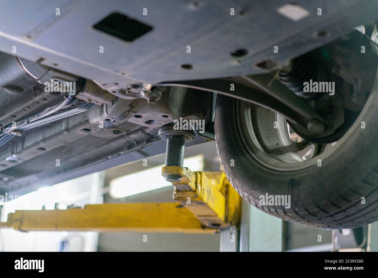 the yellow lift hand at the lifting safety mark under the car. Lifted ...