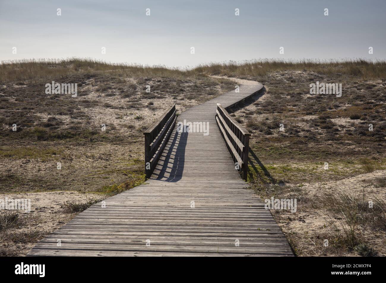 View of a wooden walkway with a small bridge to a vast desert landscape ...