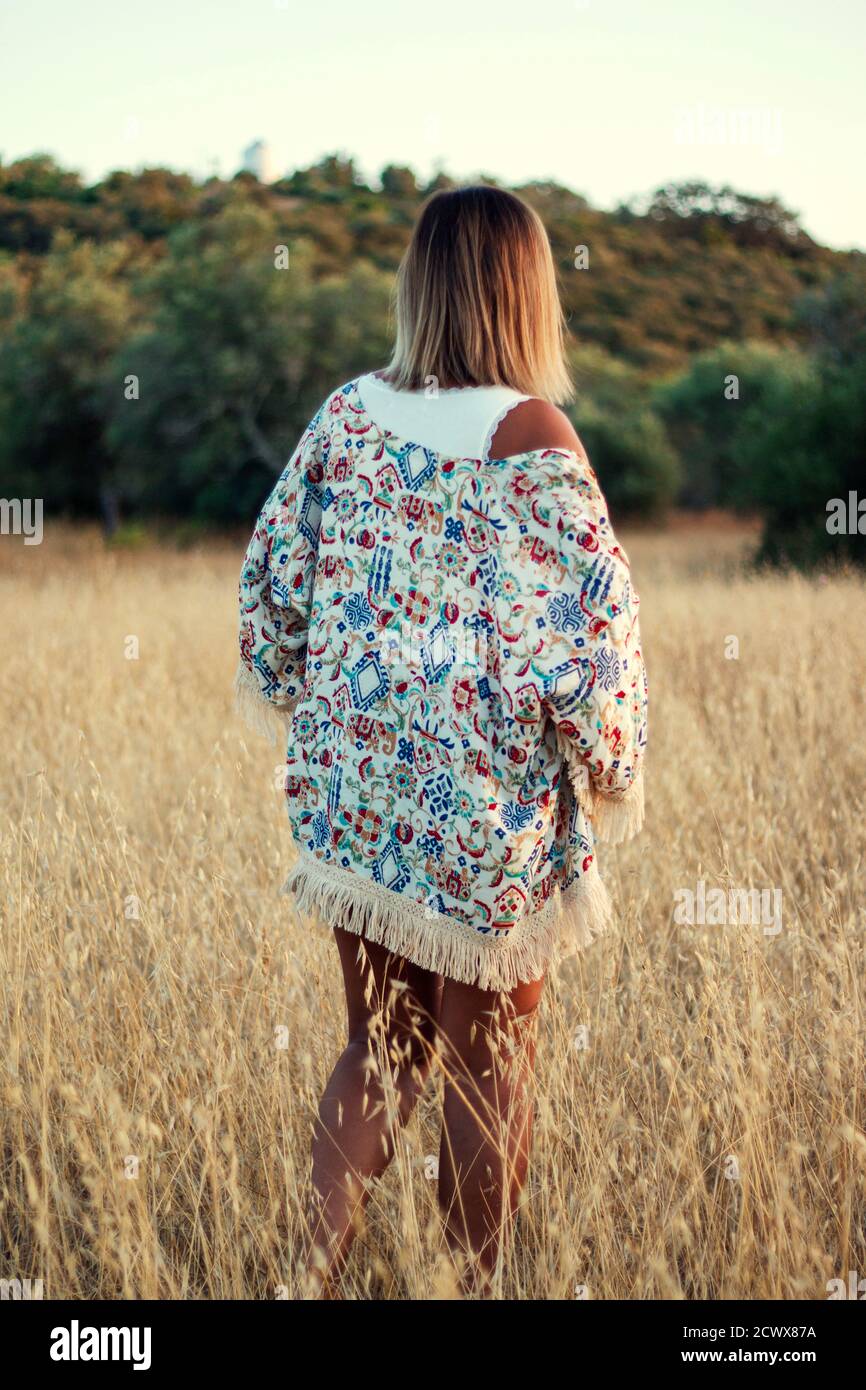 Beautiful girl posing on the countryside with short jeans on the dry ...