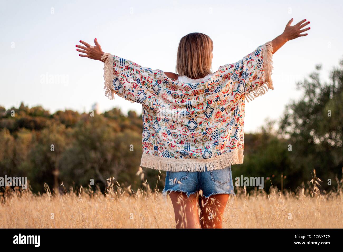 Beautiful girl posing on the countryside with short jeans on the dry ...