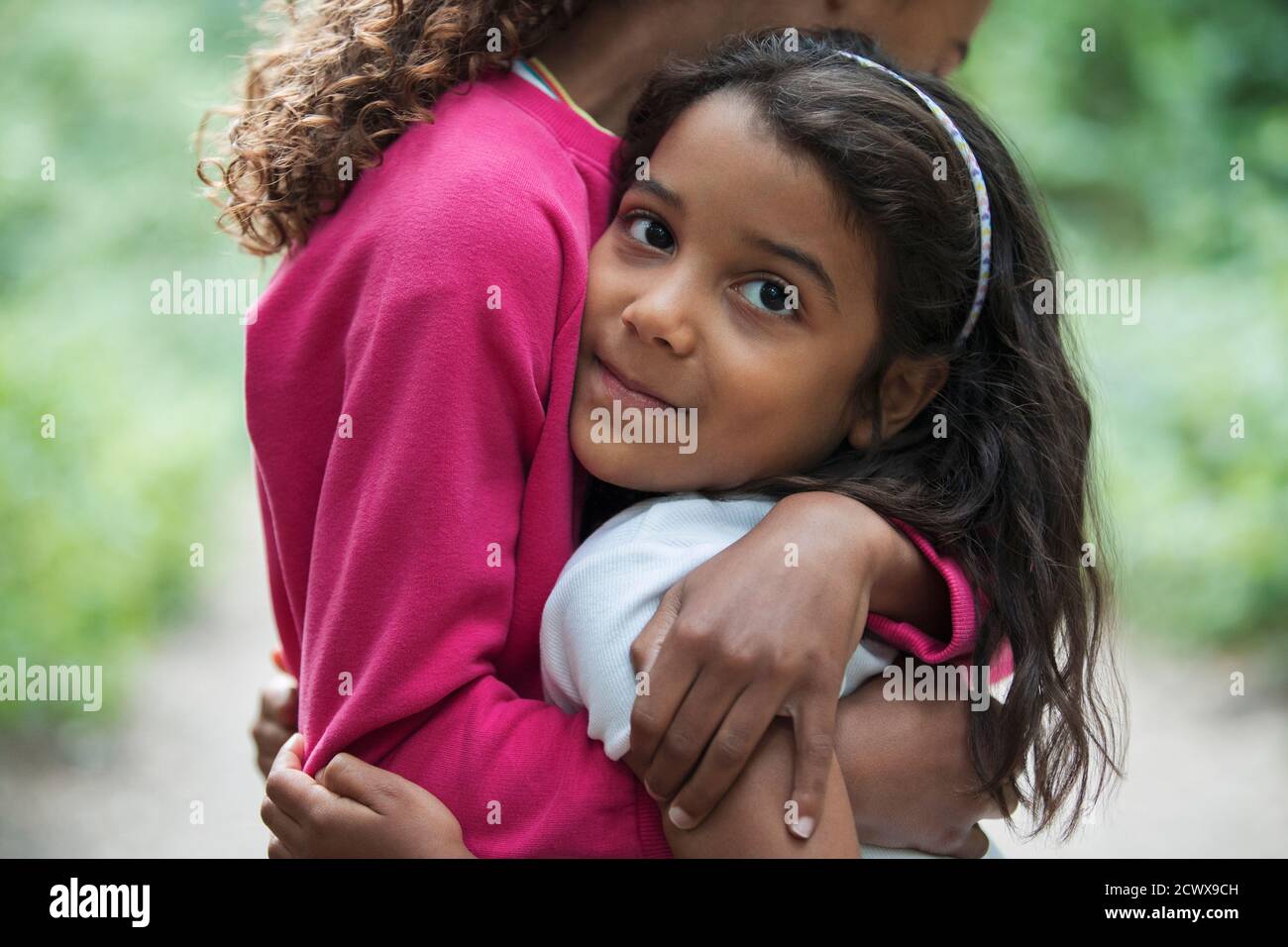 Portrait cute girl hugging sister Stock Photo - Alamy