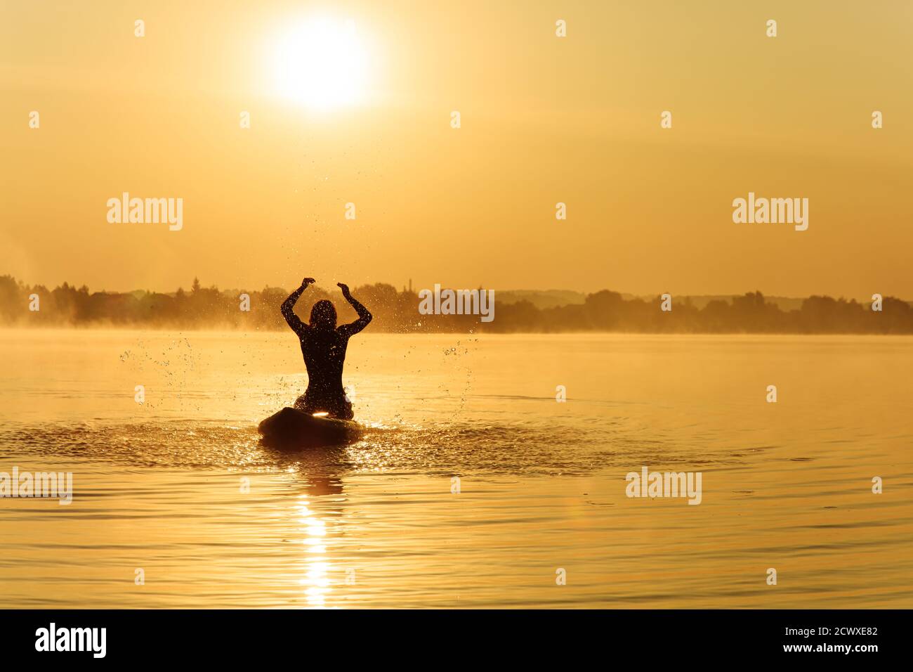 Happy man surfing on paddle board and splashing water Stock Photo - Alamy