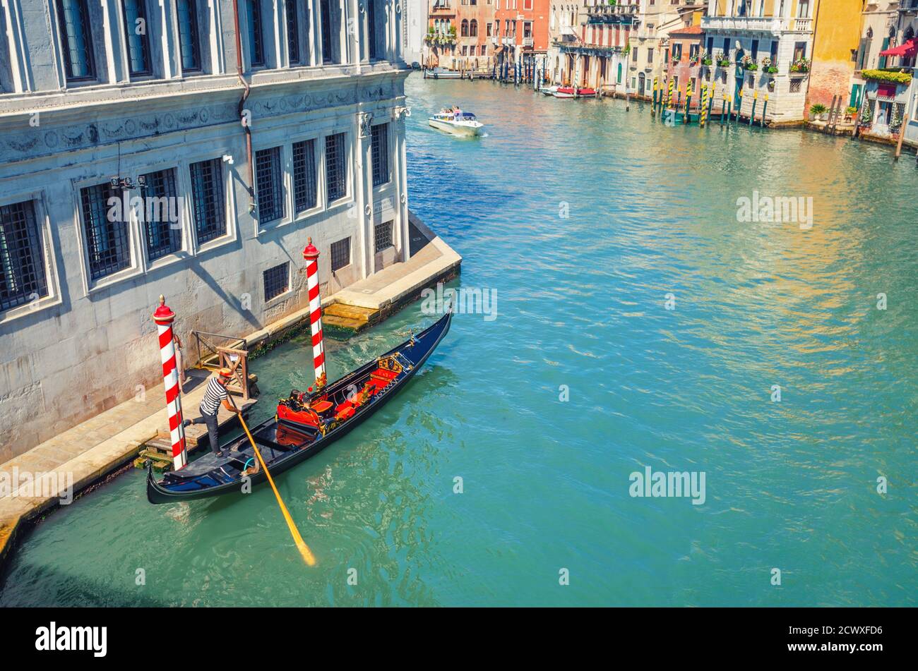 Gondolier on sailing gondola traditional boat in water of Grand Canal ...