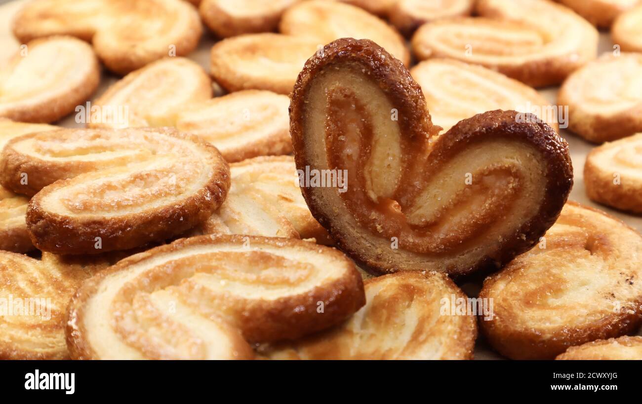 Fresh puff pastry palm cookies in the shape of a heart. Classic French ...