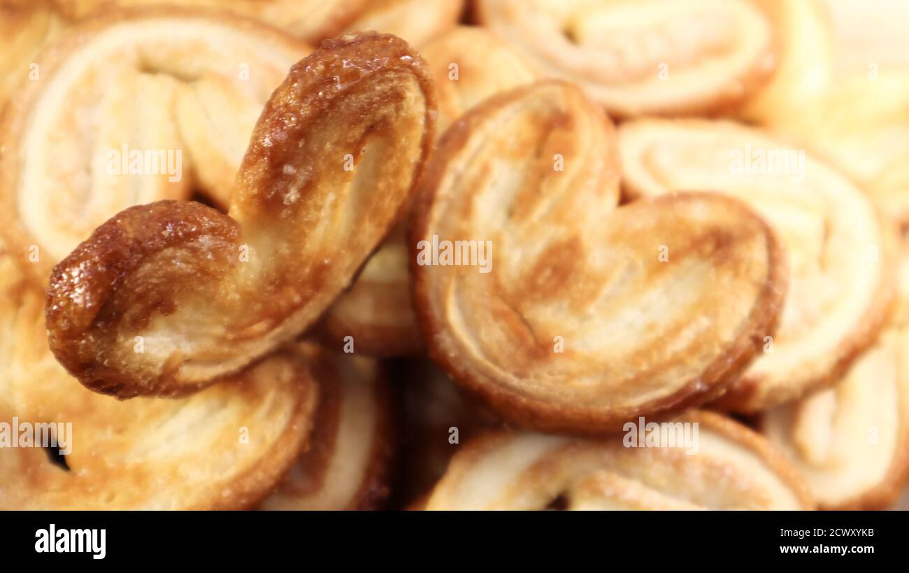 Fresh puff pastry palm cookies in the shape of a heart. Classic French ...