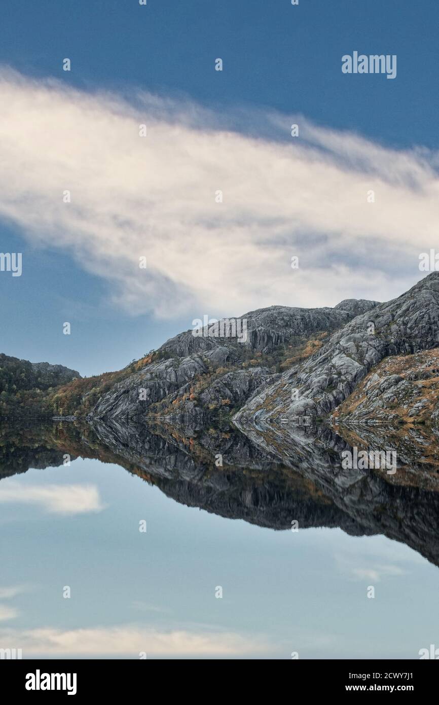 Fjord with stone shills on shore and water reflecting blue sky Stock ...