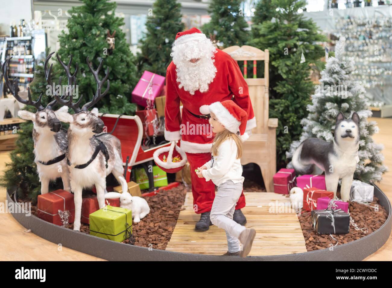 Girl in a hat visiting Santa Claus Stock Photo - Alamy