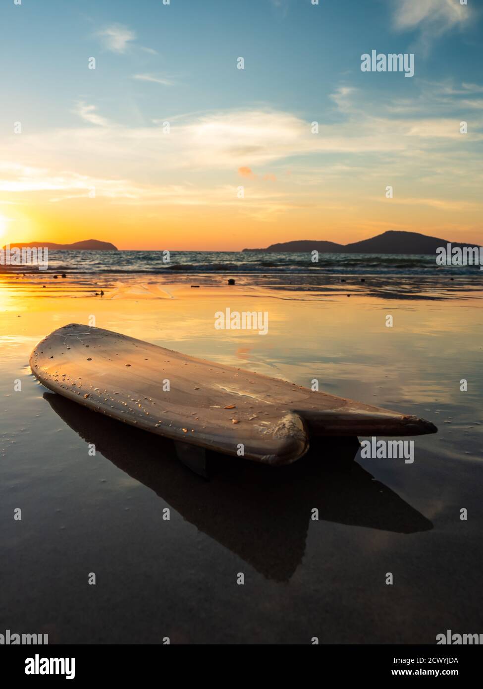 Surfboard on the beach at sunset Stock Photo - Alamy